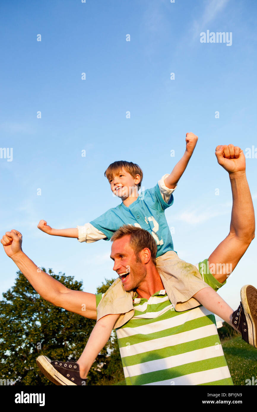 Father With Son on Shoulders Cheering Stock Photo - Alamy