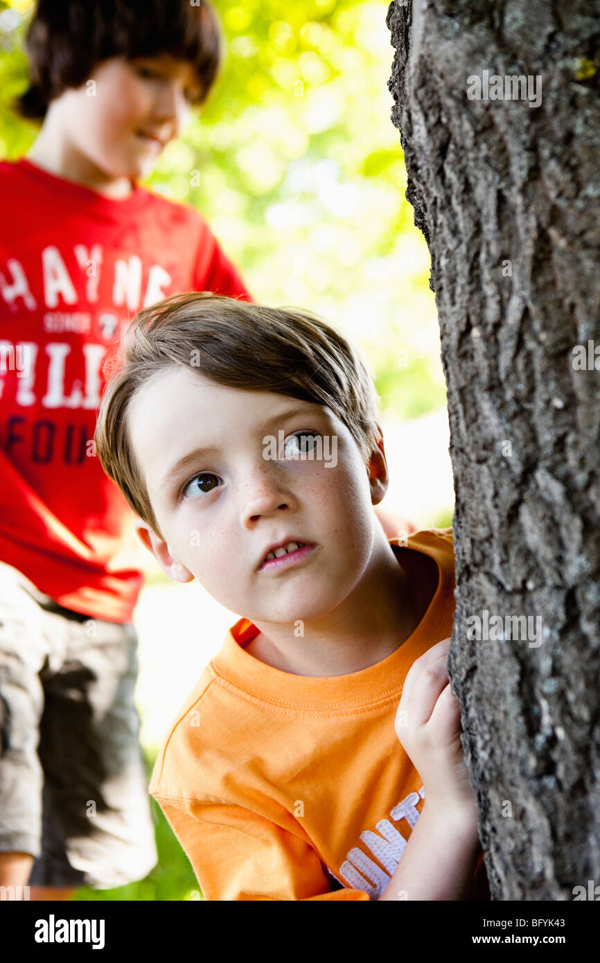 Two Boys Hiding Behind Tree Stock Photo - Alamy