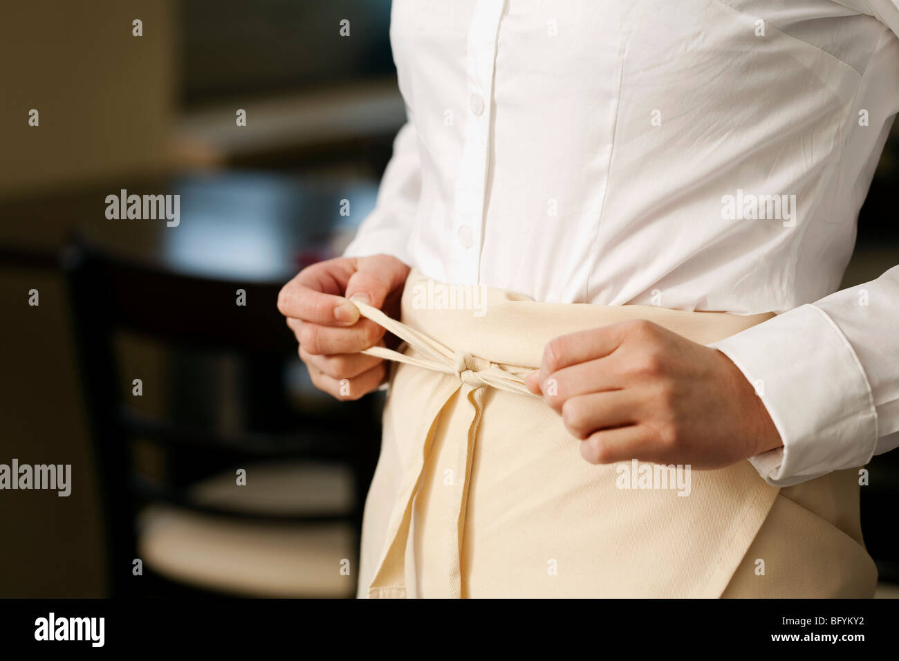 close-up of waitress in restaurant tying apron Stock Photo - Alamy