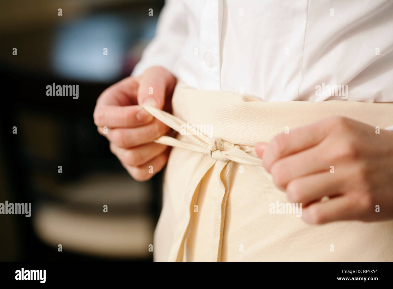 close-up of waitress in restaurant tying apron Stock Photo - Alamy
