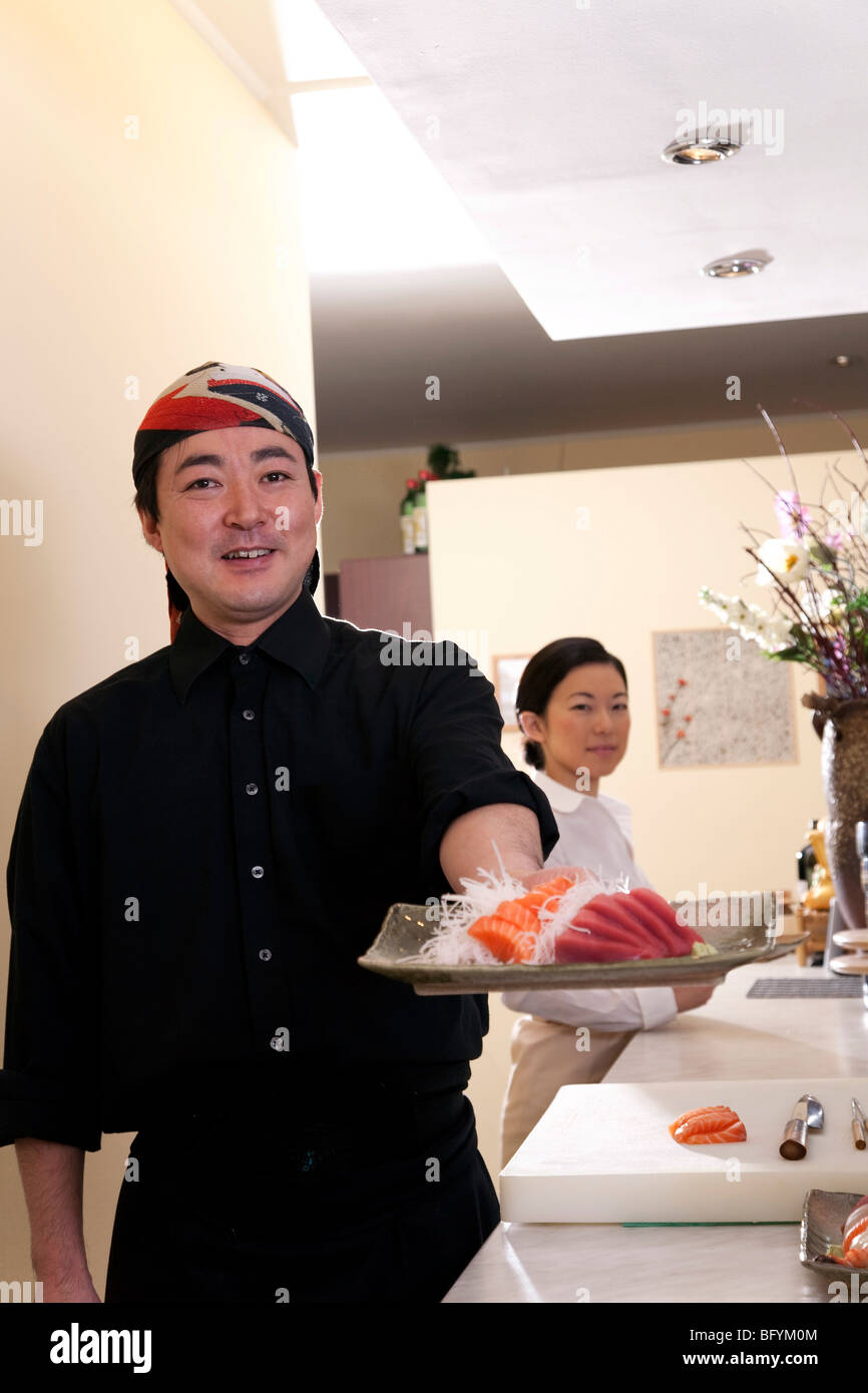 portrait of japanese chef presenting plate with sushi Stock Photo - Alamy