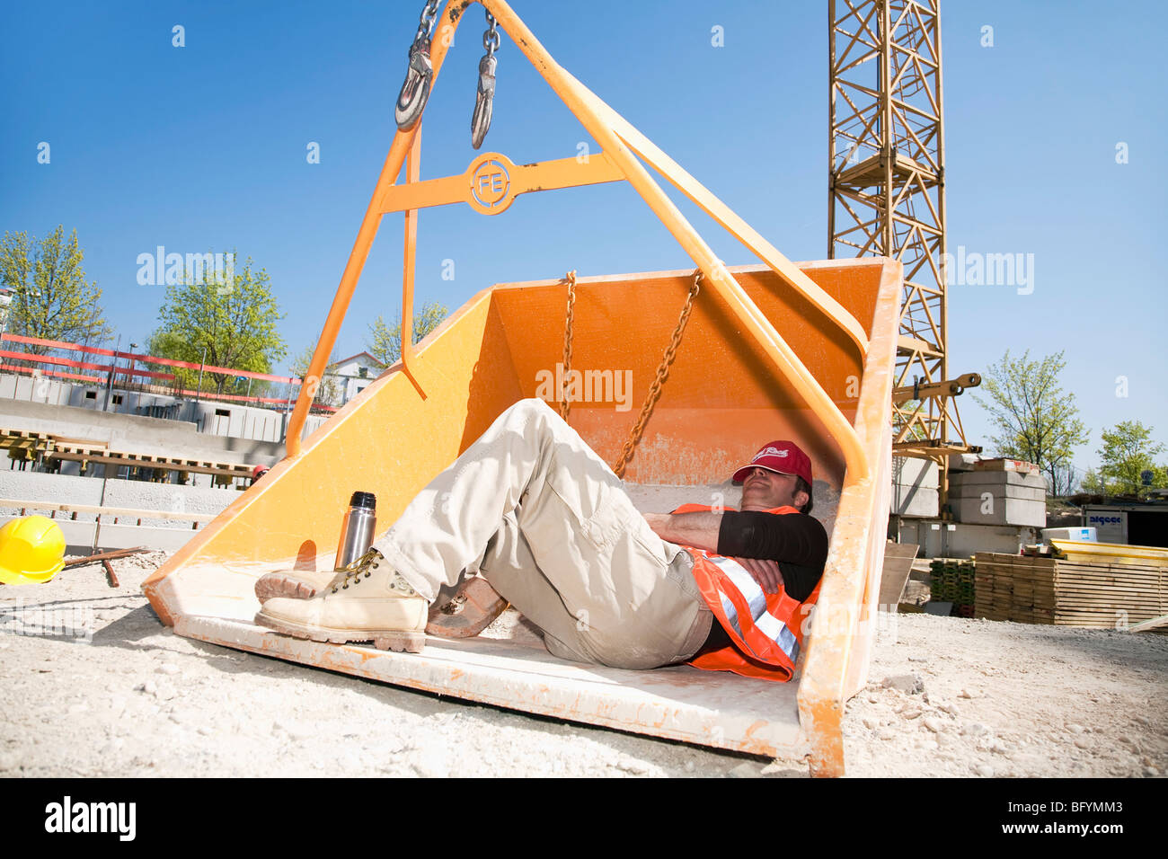 construction worker taking a nap in tipping skip Stock Photo - Alamy