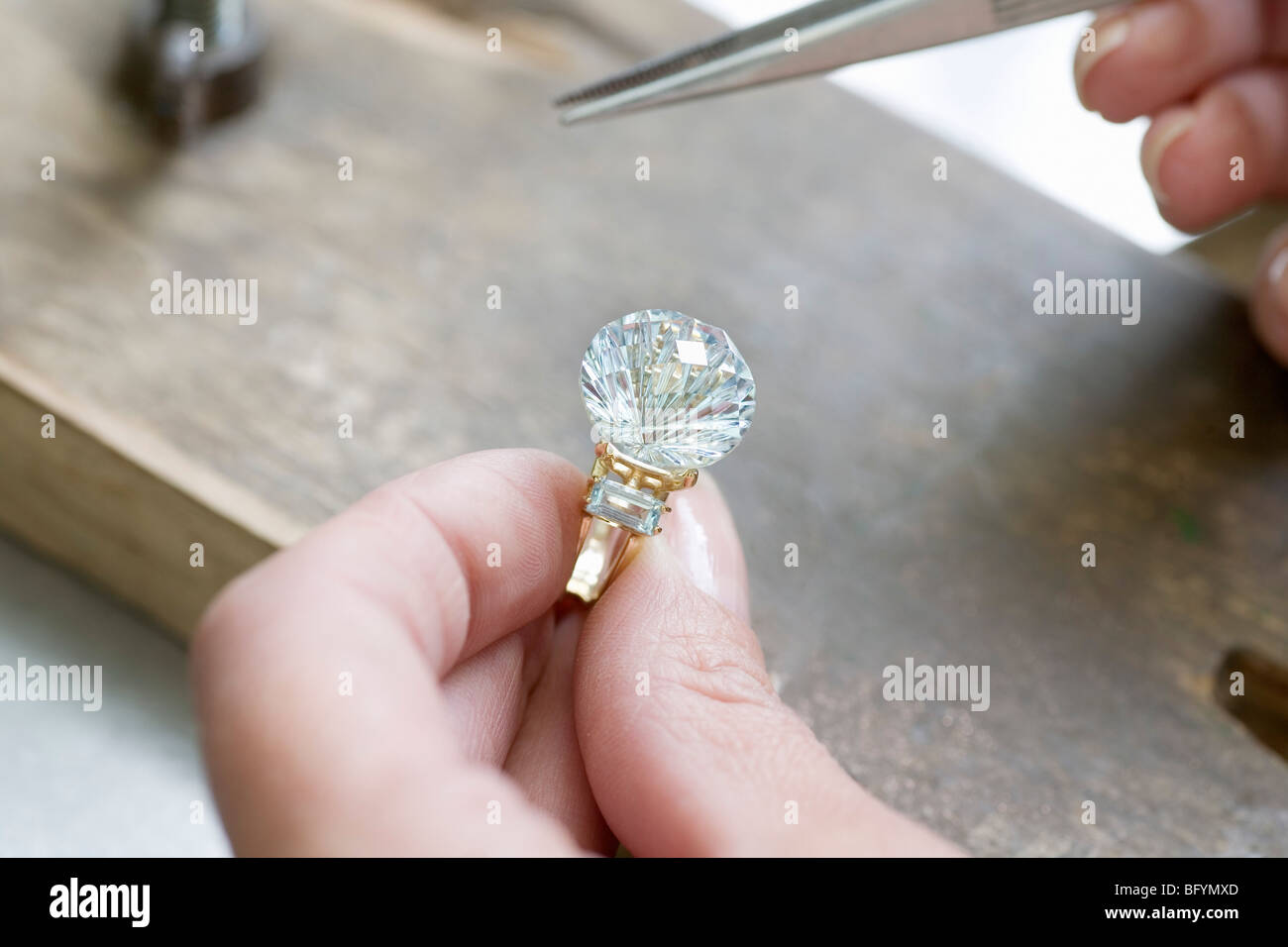 close-up of woman putting diamond on golden ring Stock Photo - Alamy