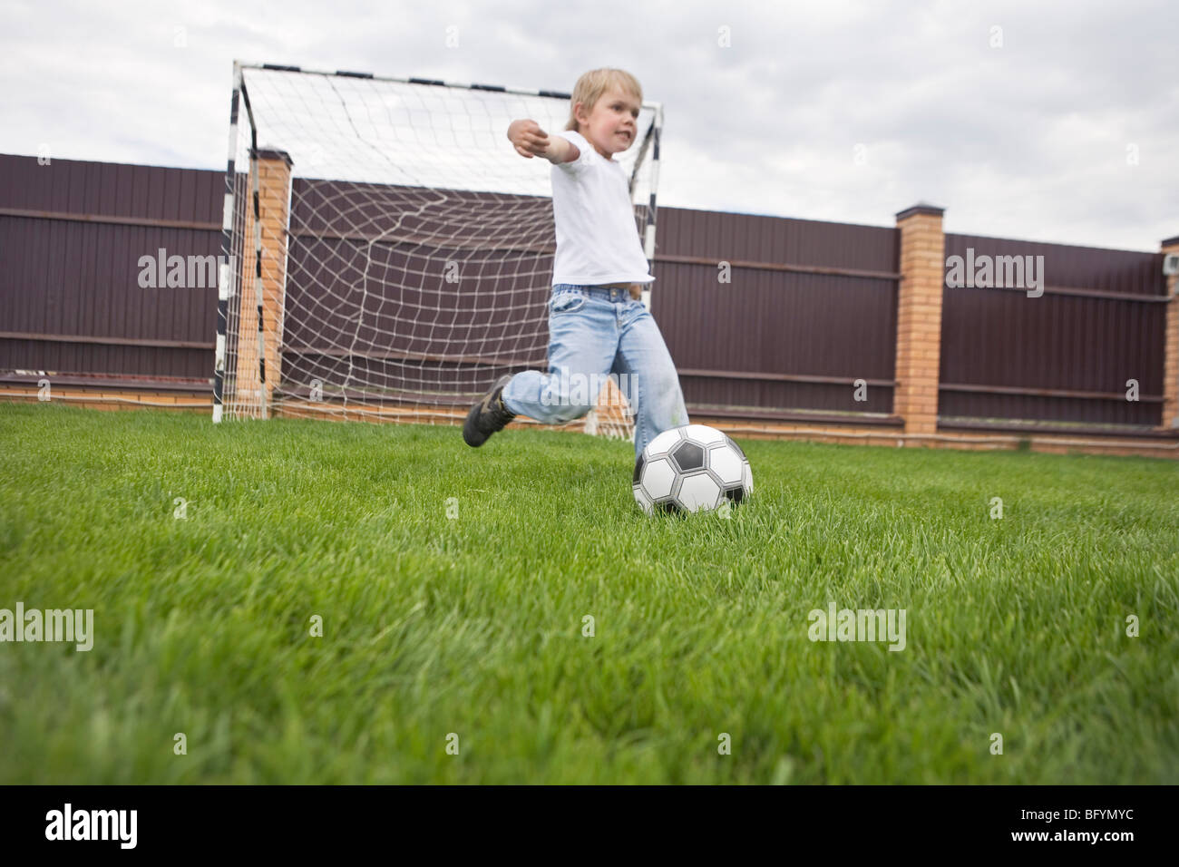 young boy kicking football Stock Photo - Alamy