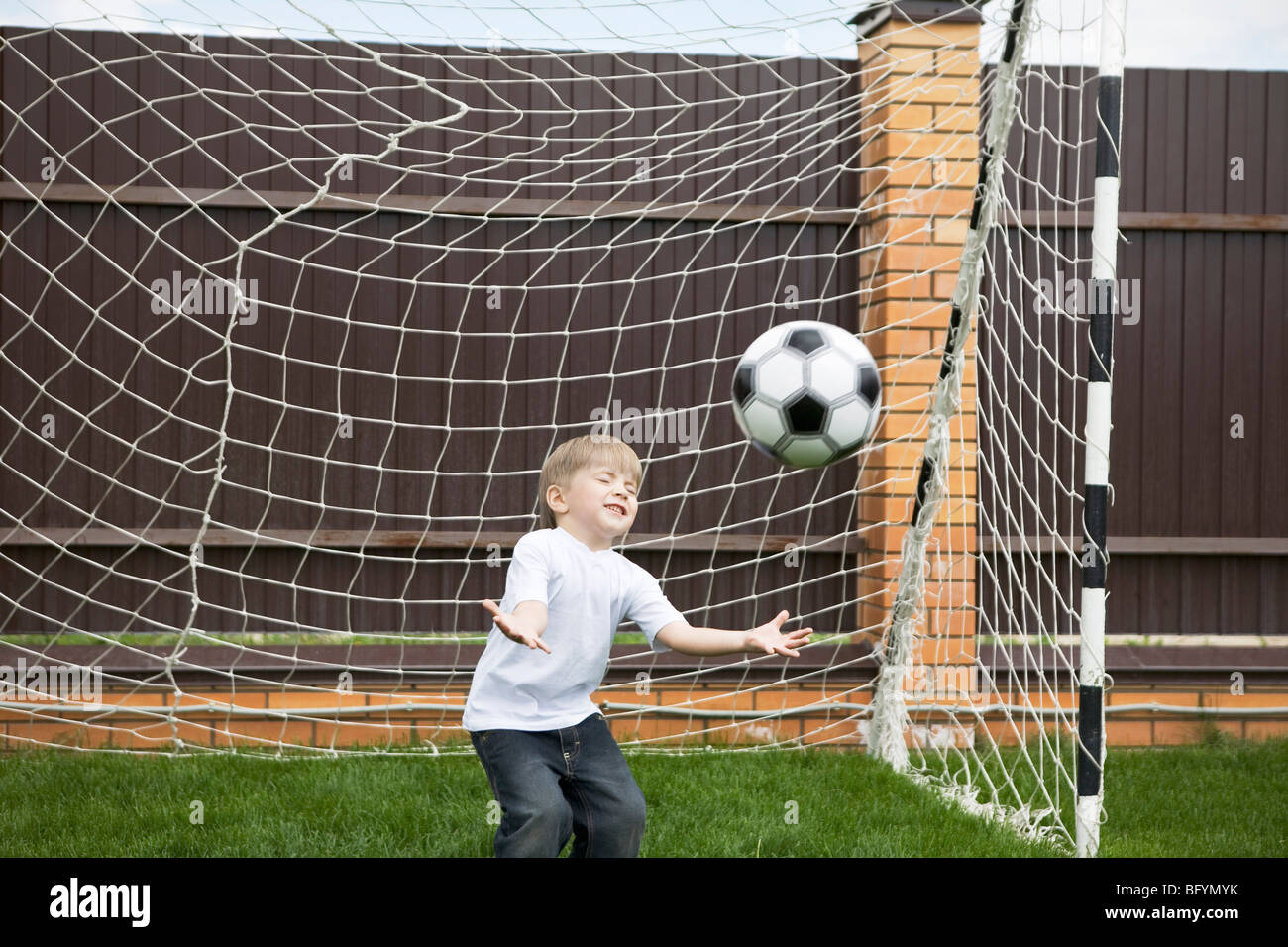 young boy standing in football goal catching ball Stock Photo - Alamy