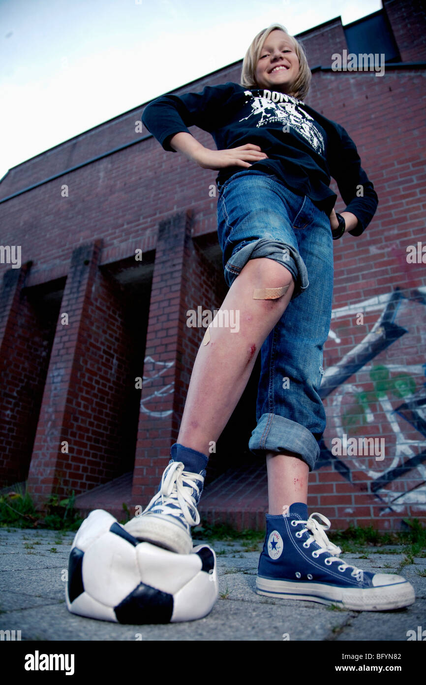 portrait of blond boy stepping on football Stock Photo - Alamy