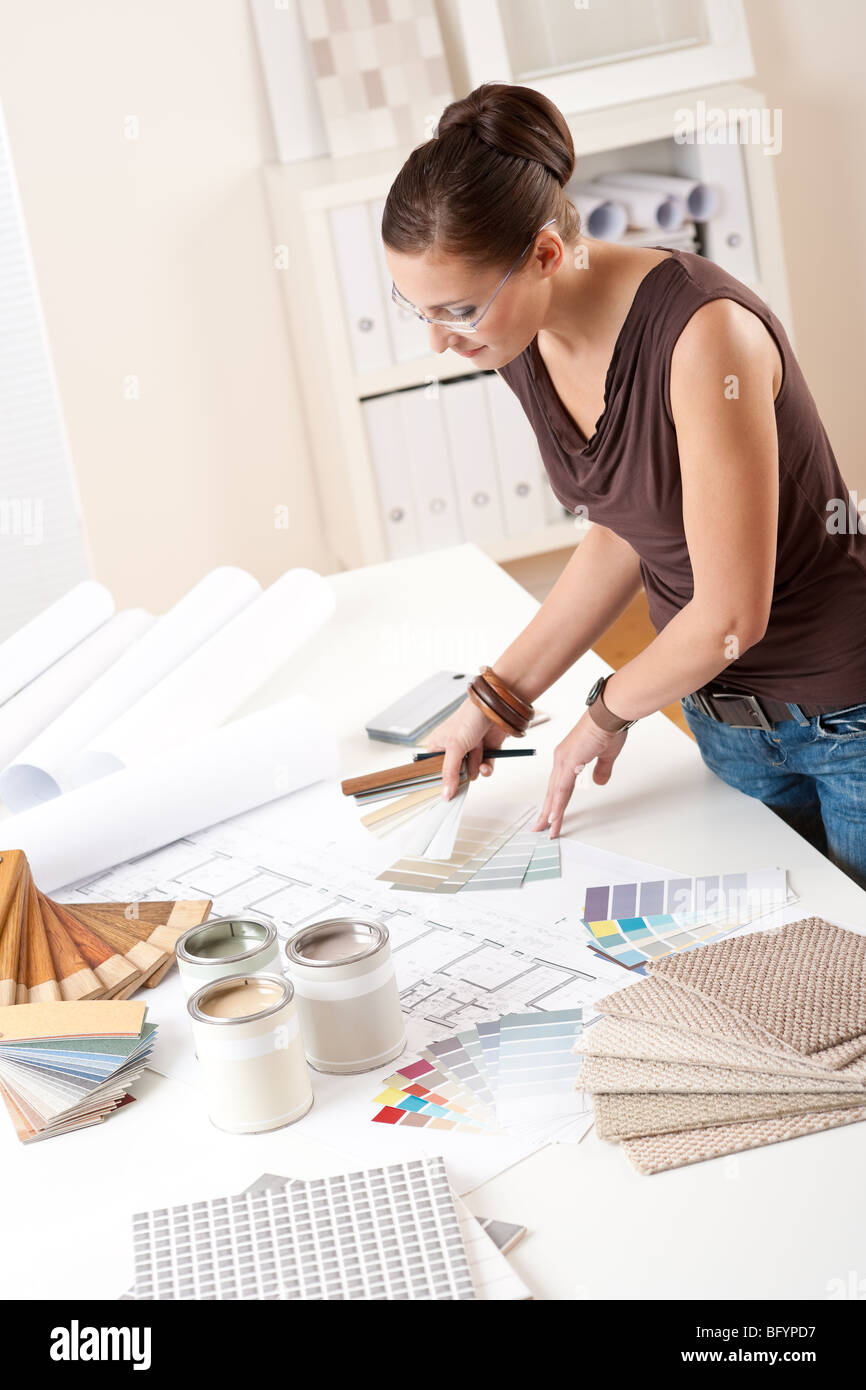 Young successful interior designer woman with cans of paint and color ...