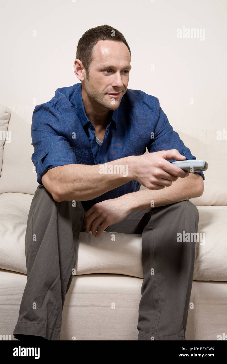 Man watching television in his living room Stock Photo - Alamy