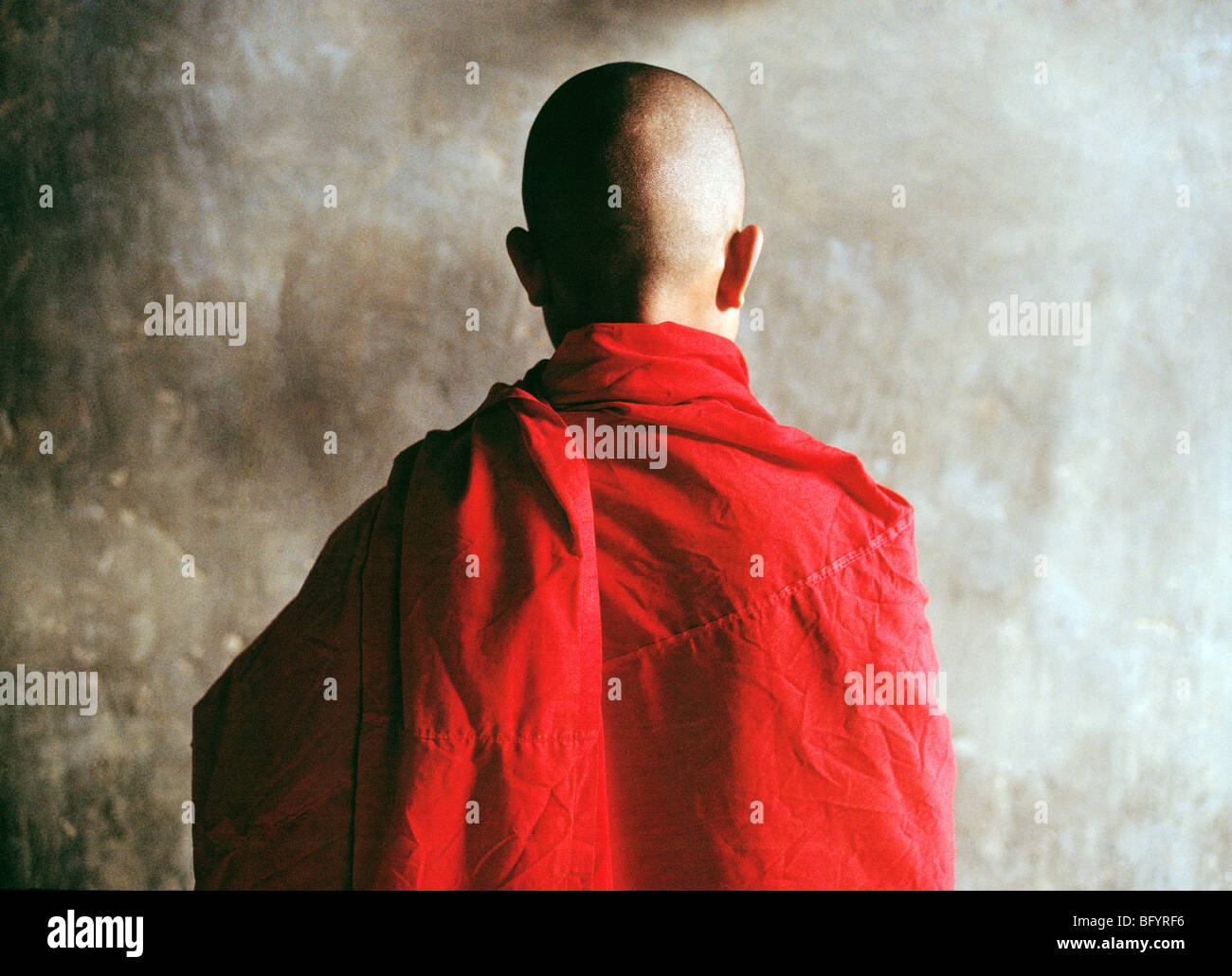 Young Chinese Buddhist monk looking at wall in silence Stock Photo - Alamy