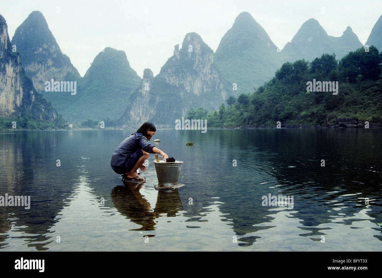 Chinese woman washes clothes in Lin River near Yangshuo, China Stock ...