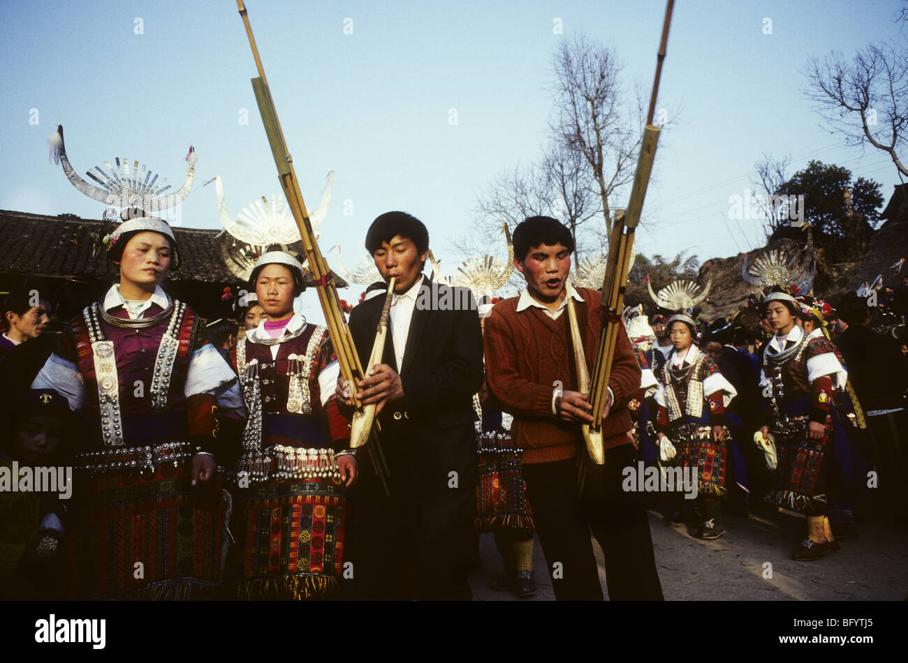 A Miao festival procession near Kaili, China with young men playing the ...