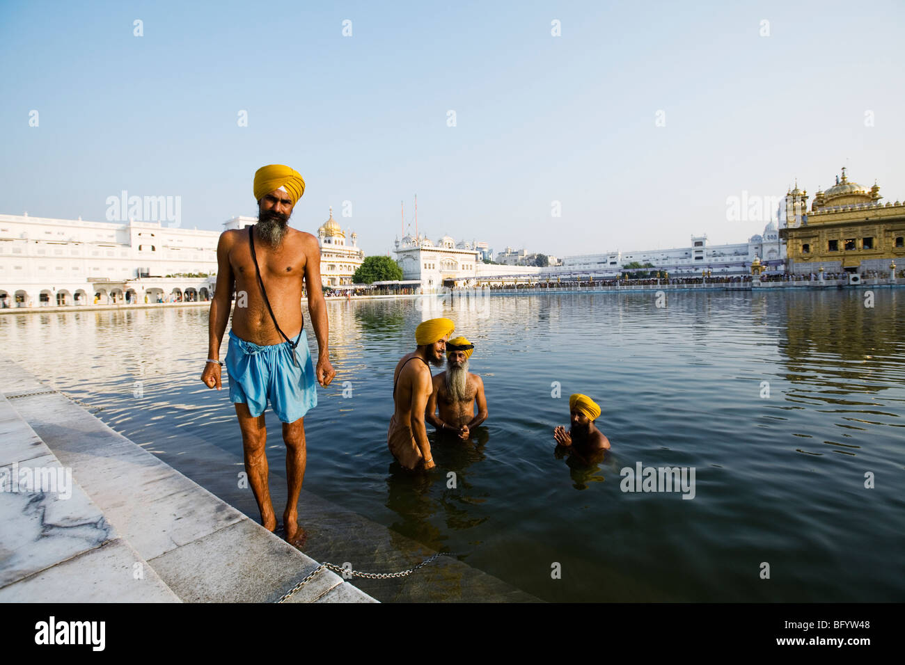 Sikh men taking a religious bath in Golden Temple, Amritsar, India ...