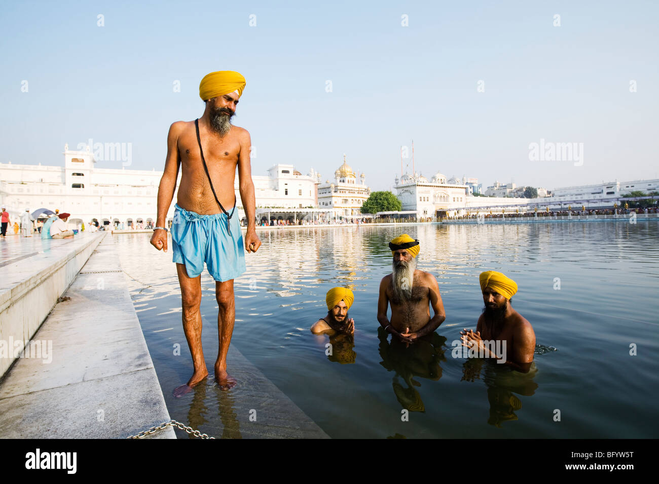 Sikh men taking a religious bath in Golden Temple, Amritsar, India ...