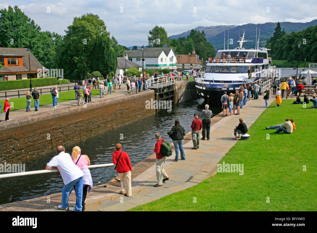 people watching a yacht moving into the lock at Fort Augustus, Scotland ...