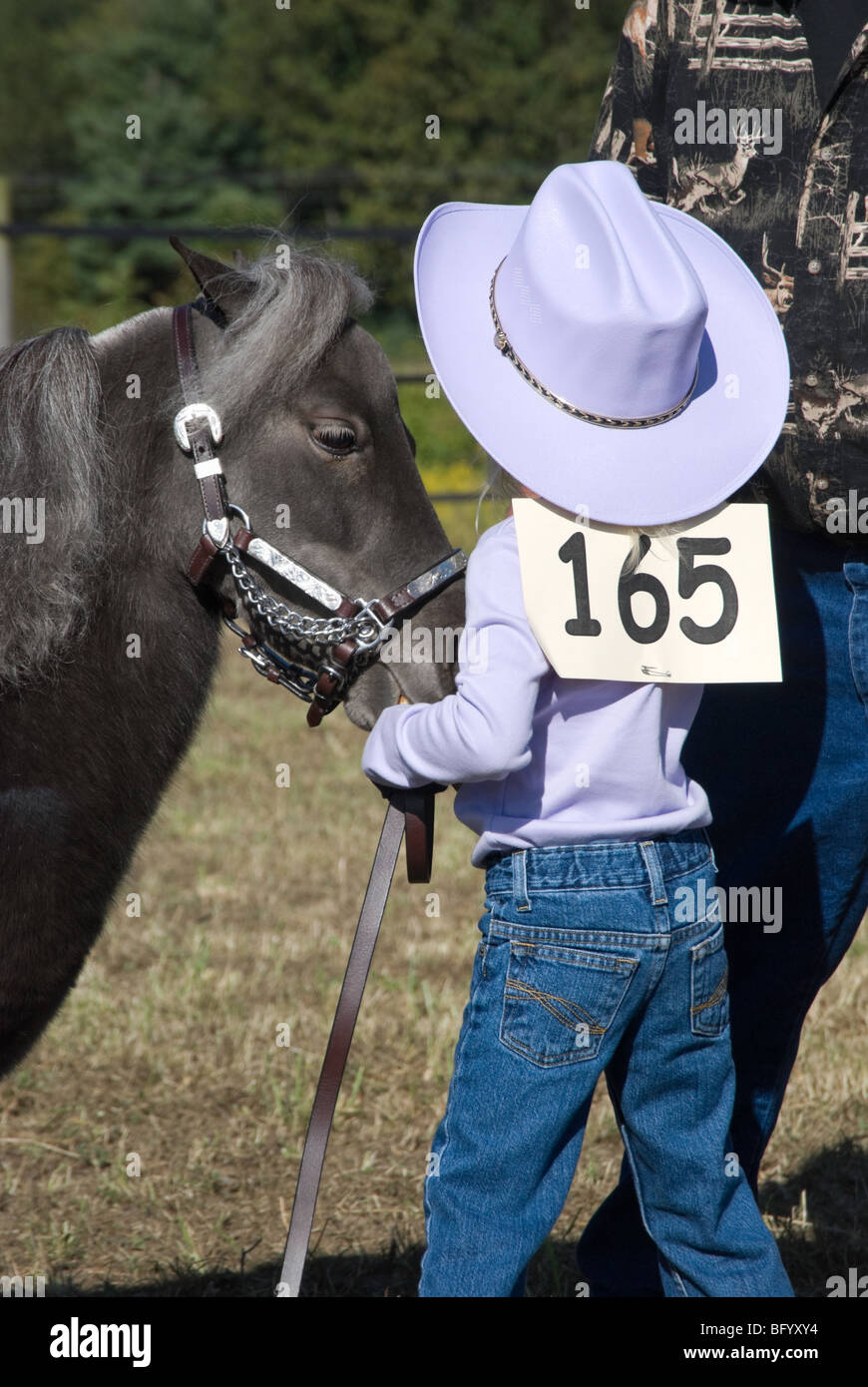 Young girl with lavender top and cowboy hat competing a halter class at ...