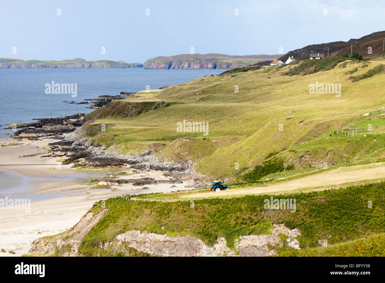 A tractor cutting hay on a clifftop field at Coldbackie, Highland ...