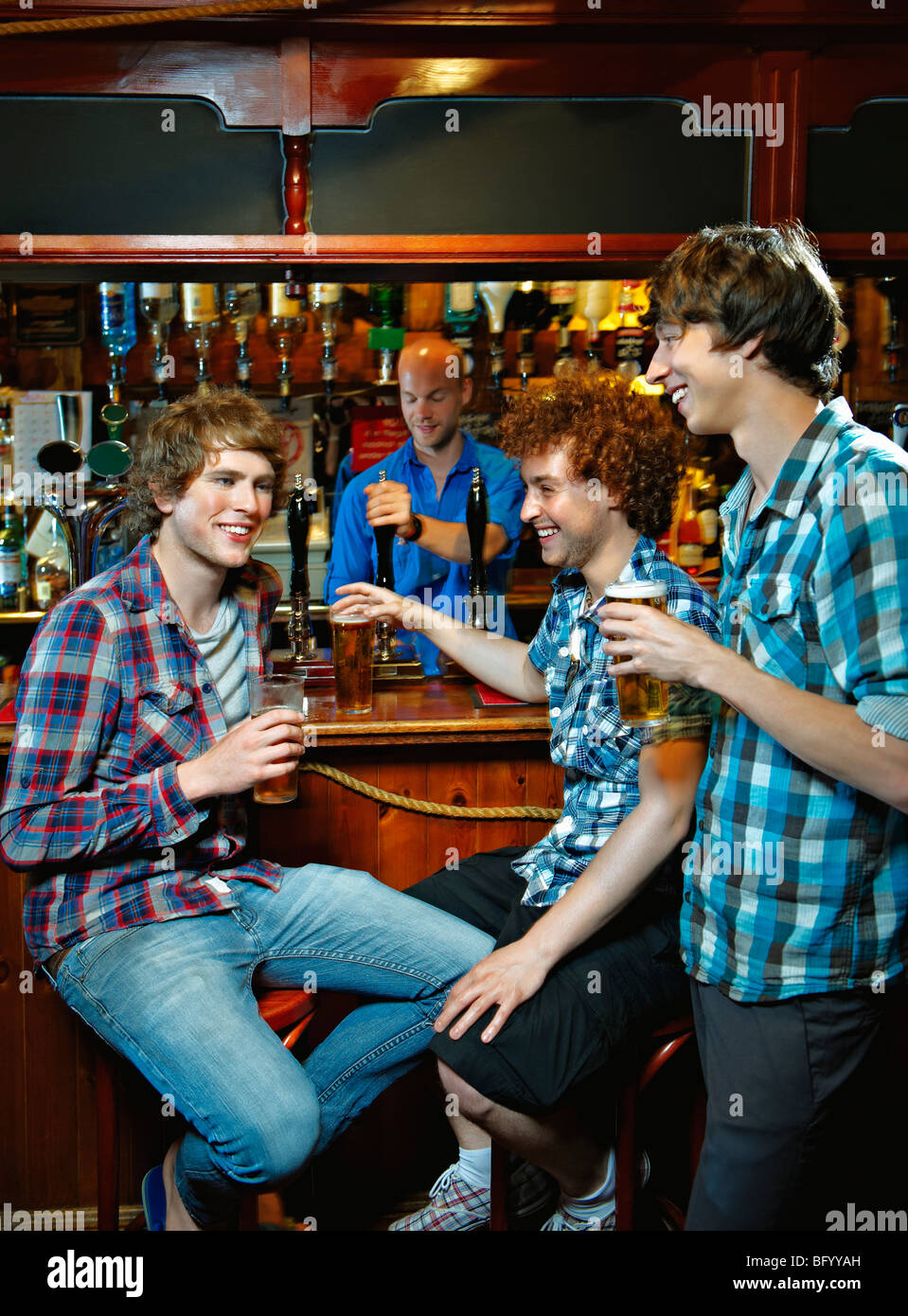 Young men drinking in pub Stock Photo - Alamy