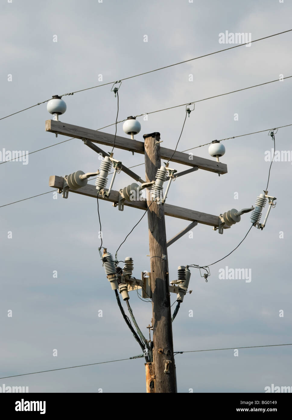 Utility power pole and electrical transmission wires against blue sky ...