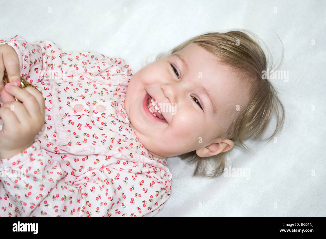 Little happy child lies in white floor and smiling Stock Photo - Alamy