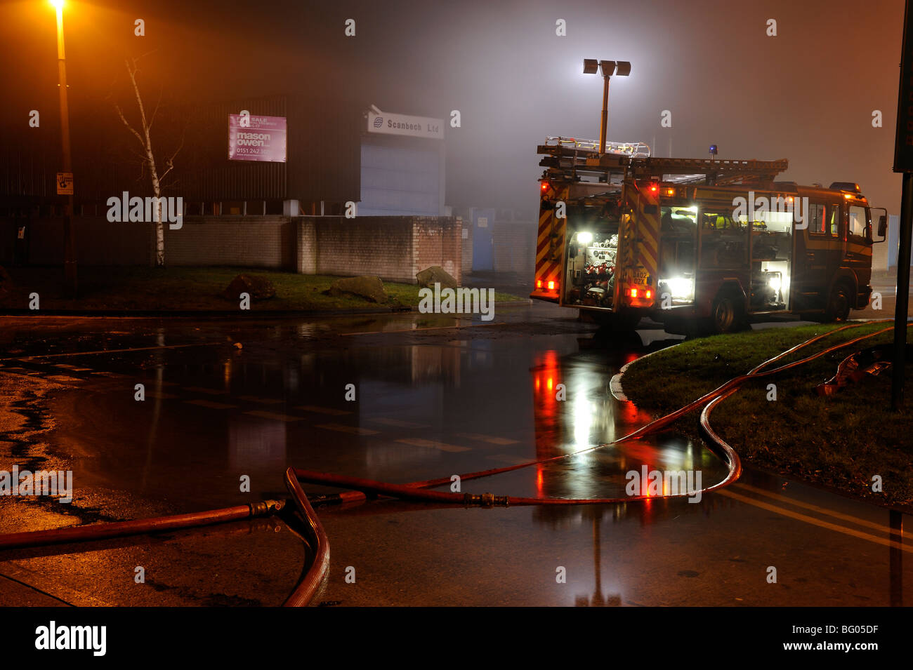 Fire engine at warehouse fire at night with water reflections Stock ...