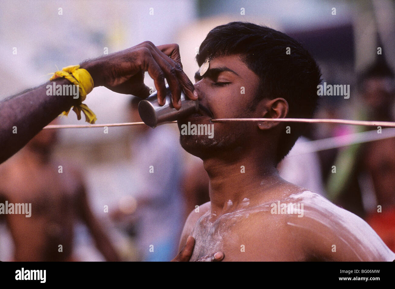 A pilgrim takes a drink to stay hydrated during the annual Hindu ...