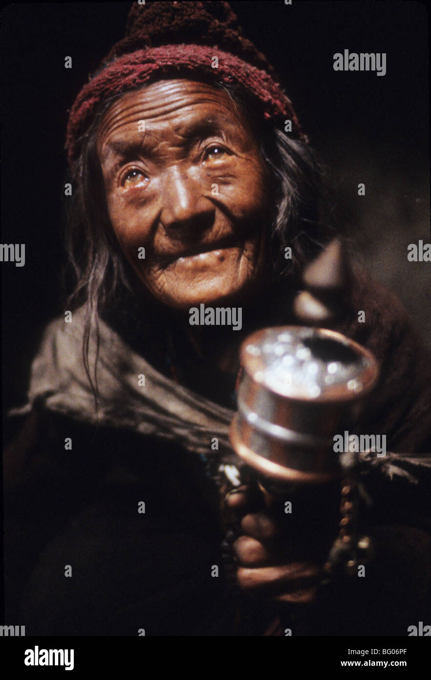 Portrait of a Tibetan Buddhist Ladakhi woman with a prayer wheel in the ...
