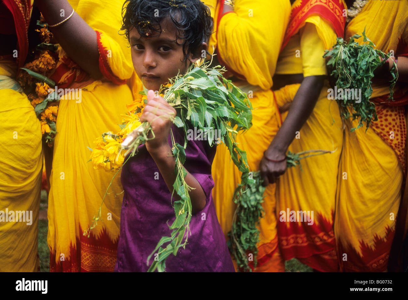 A young girl waits in line with her mother and other South India women ...