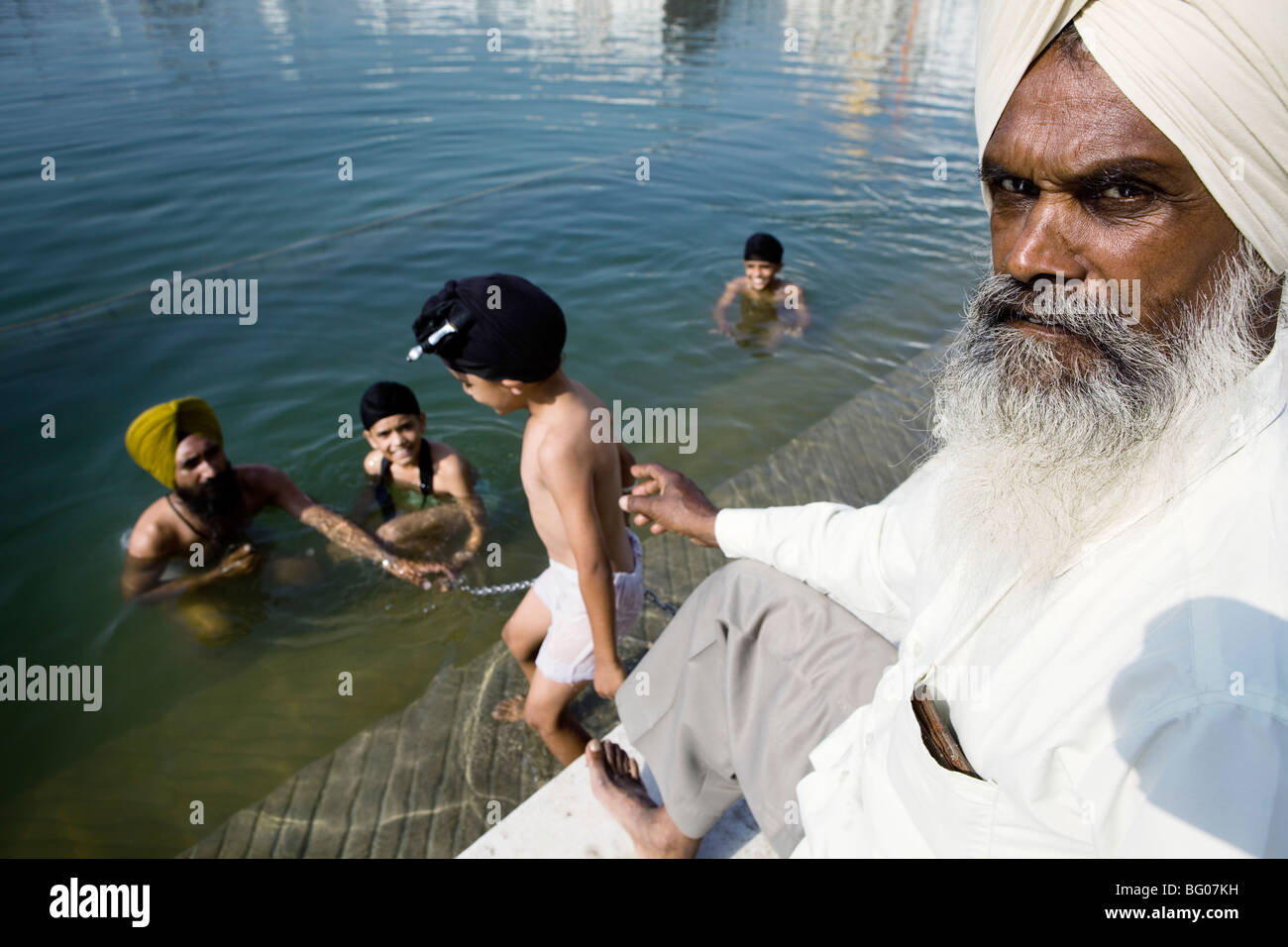 Sikh family taking a religious bath in Golden Temple, Amritsar, India ...