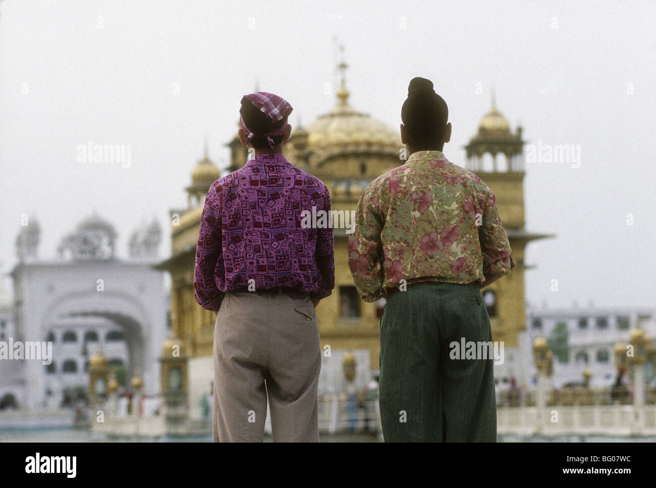 Two Sikh boys praying in front of the Golden Temple in Amritsar, India ...