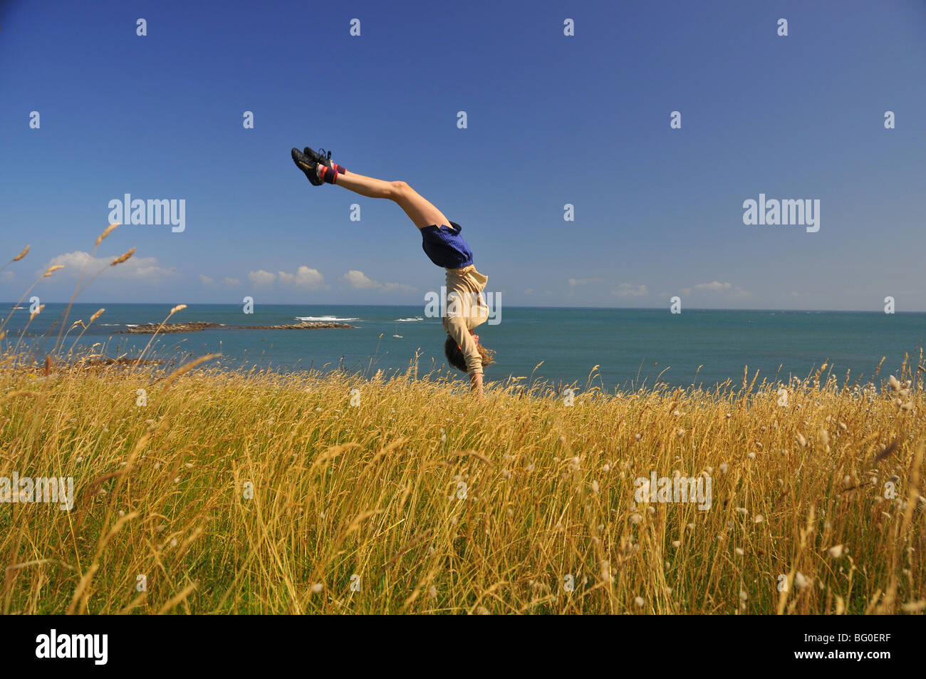 young white woman doing the wheel and jumping on the dune legs in air ...