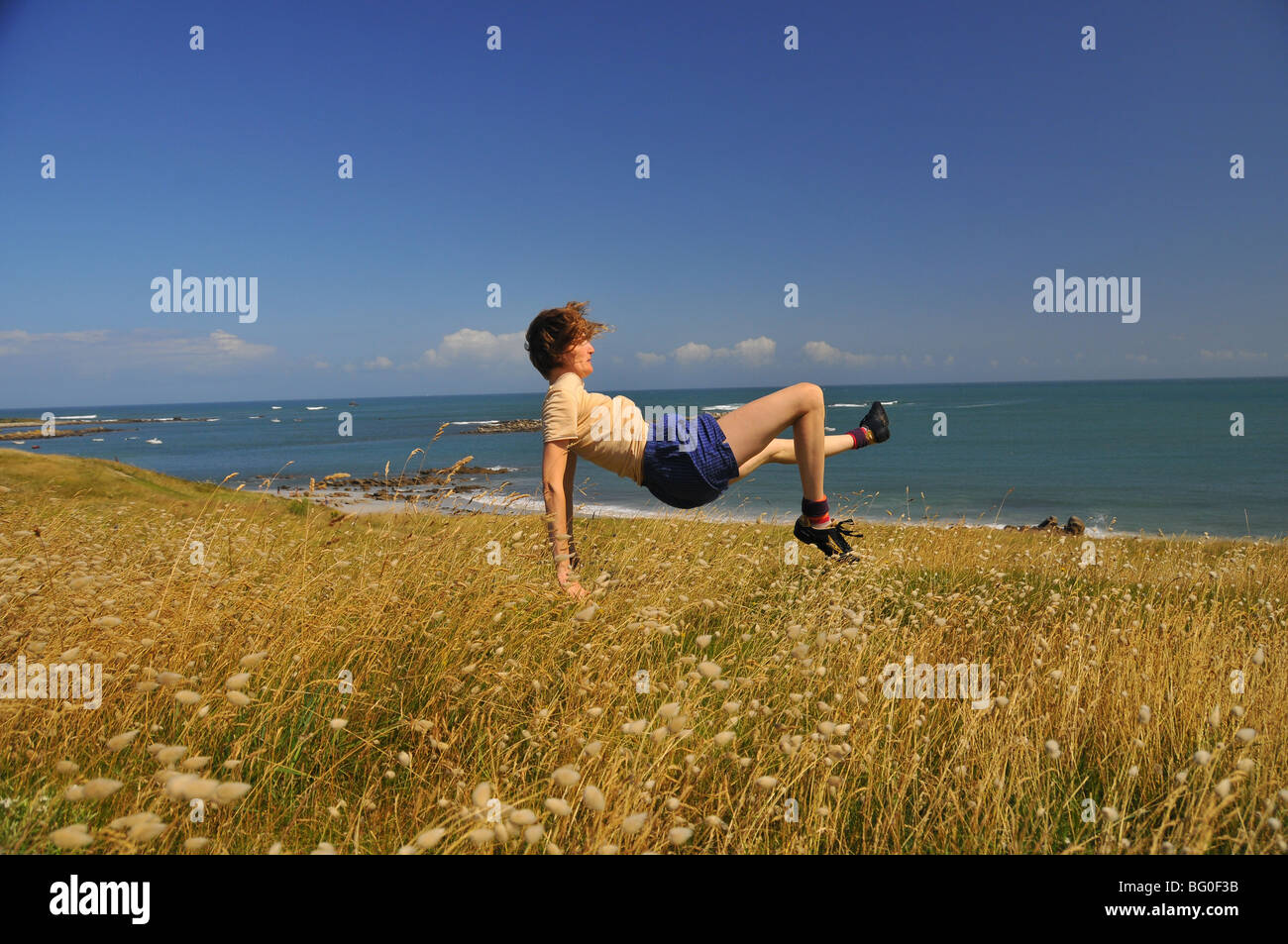 young white woman jumping and leaping on the dune legs in air and ...