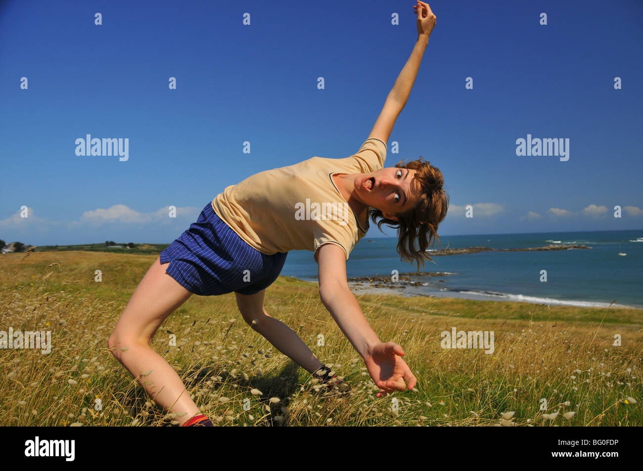 young white woman leaning back on the dune arms up imbalanced ...