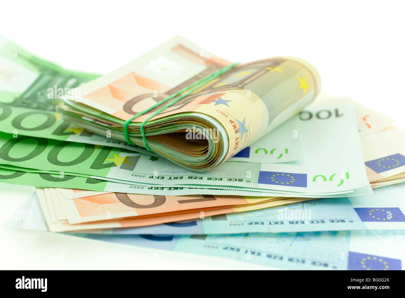 rolled with rubber euro notes on white background. closeup. small GRIP ...