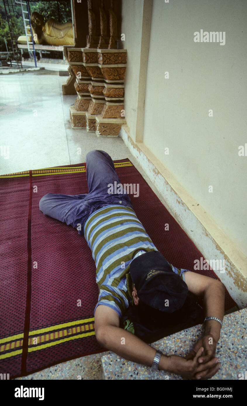 Man sleeping in Buddhist Temple across from a statue of a sleeping ...
