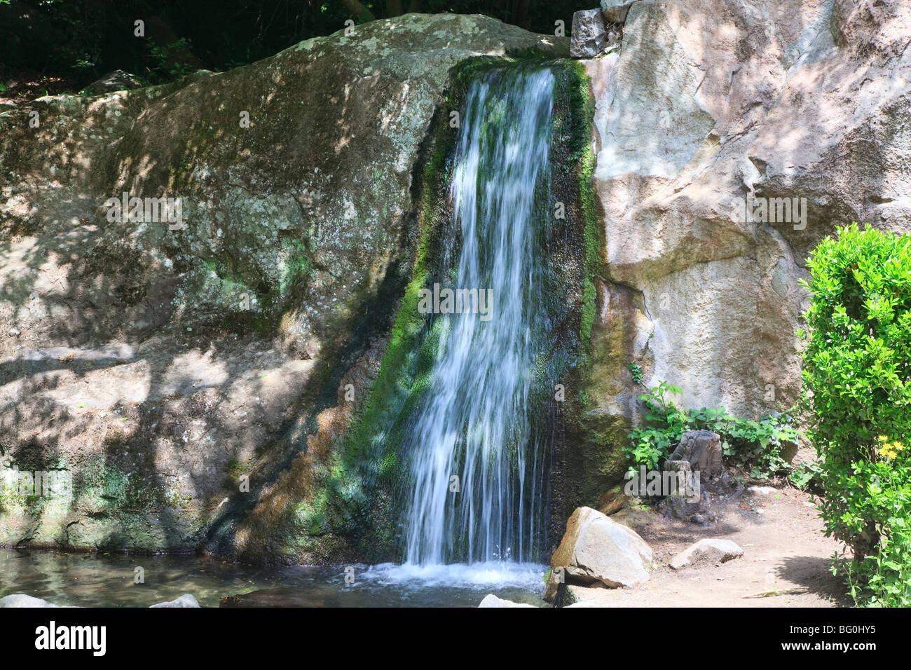 Small spring mountain waterfall and rock behind Stock Photo - Alamy