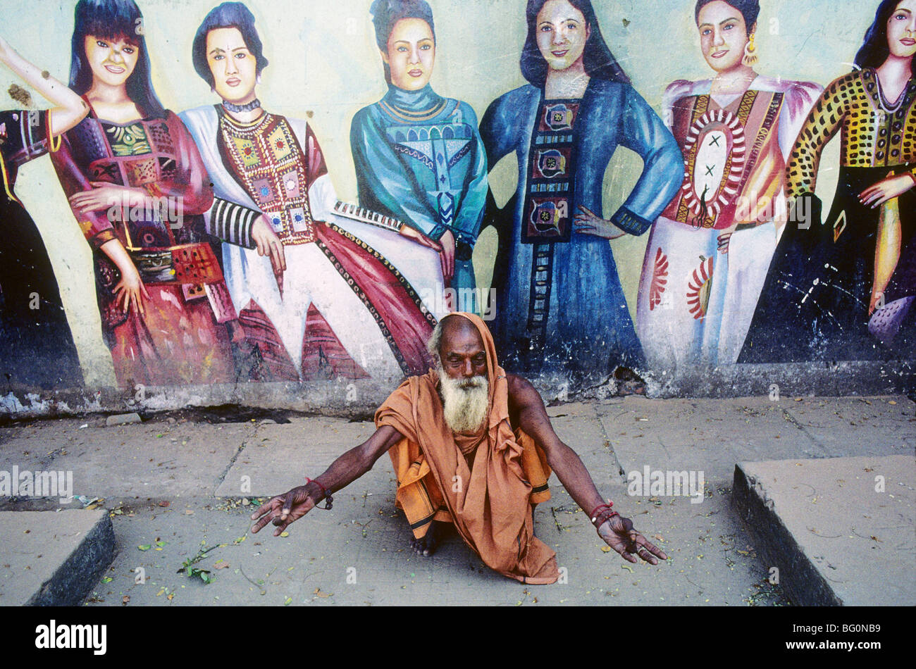 A saddhu sits on a sidewalk and holds court on his ascetic philosophy ...