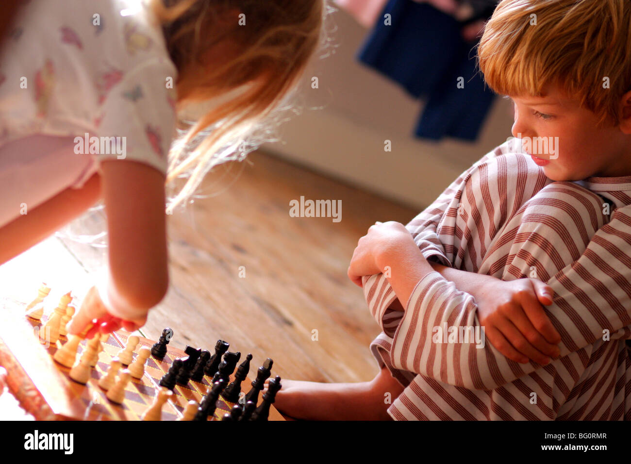 Brother and sister playing chess in thier pyjamas Stock Photo - Alamy