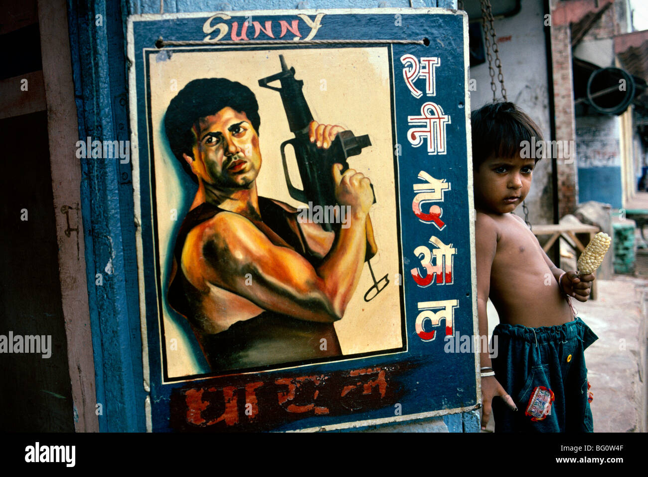A young boy stands next to a Rambo look alike in Agra, India Stock ...