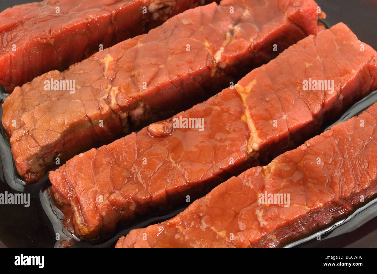Marinating steak strips Stock Photo - Alamy