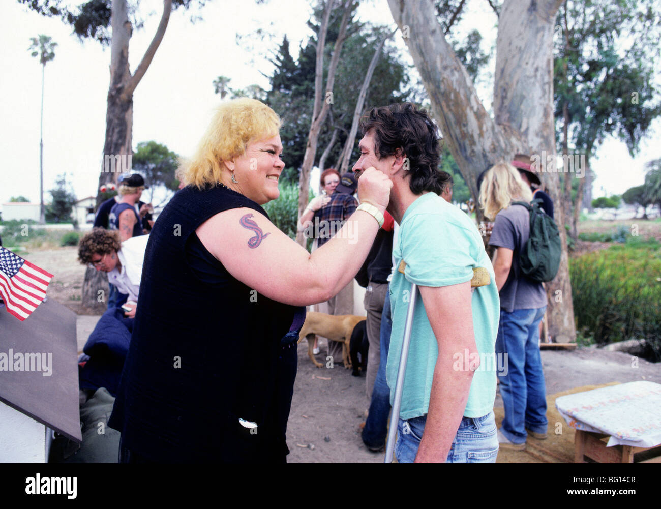 A woman pinches a mans cheek and they have a playful conversation, in ...