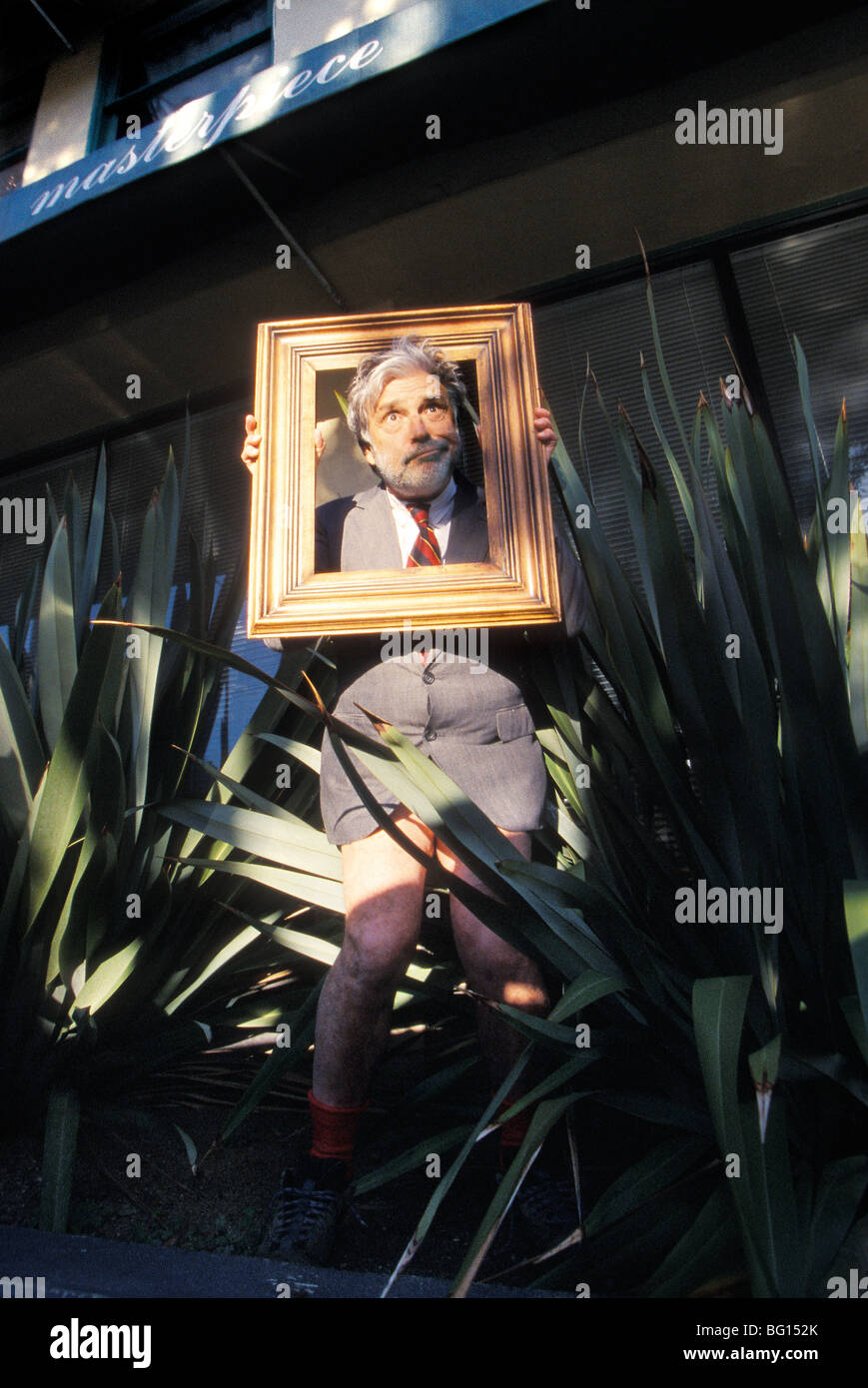 A man looks through a picture frame underneath the word masterpiece in ...