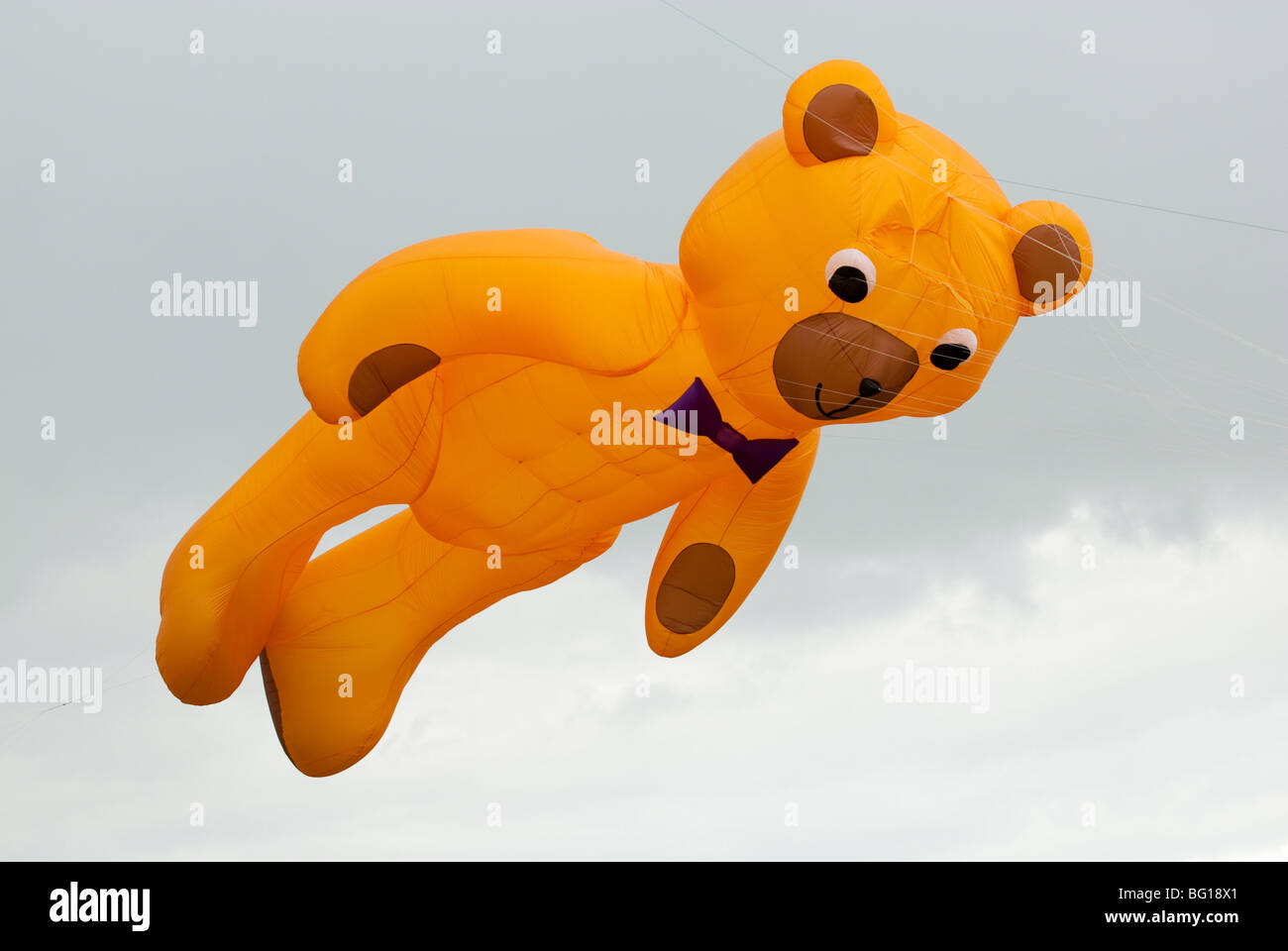 large kite flying in shape of yellow teddy bear Stock Photo - Alamy