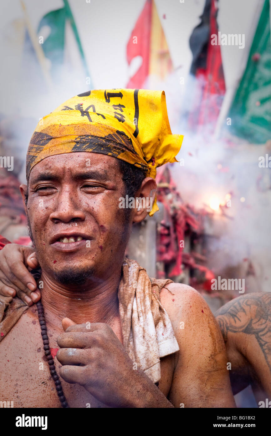A fire cracker goes off during a procession at the vegetarian festival ...
