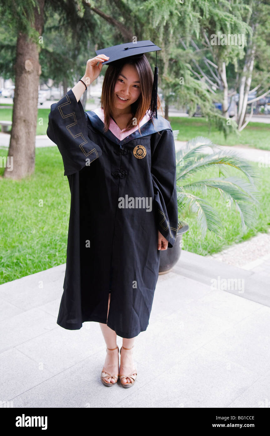 A female student on Graduation Day in front of a Chinese gate at Peking ...