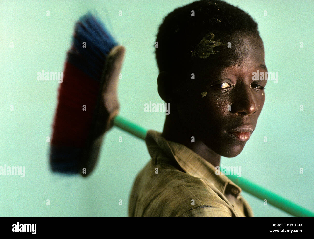 Portrait of a young man who sweeps floors in rooms in a hotel in Djenne ...