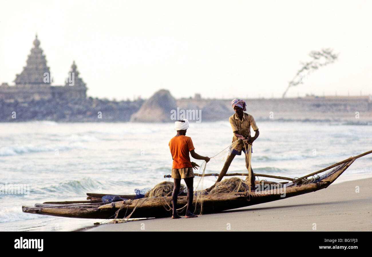 Fishermen prepare their nets before they paddle their dugout canoe ...
