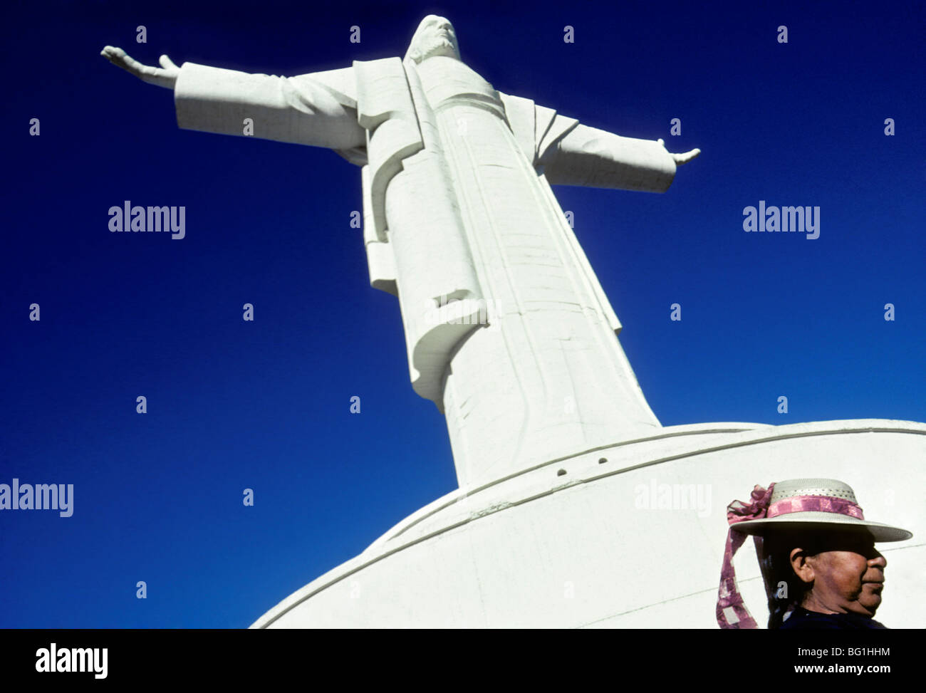 A Bolivian woman passes the Christ of Peace statue in Cochabamba ...
