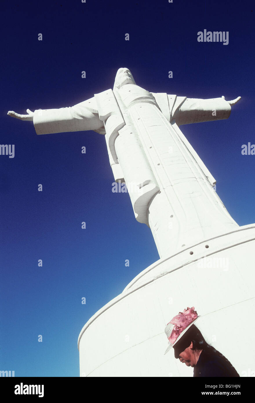 A Bolivian woman passes the Christ of Peace statue in Cochabamba ...