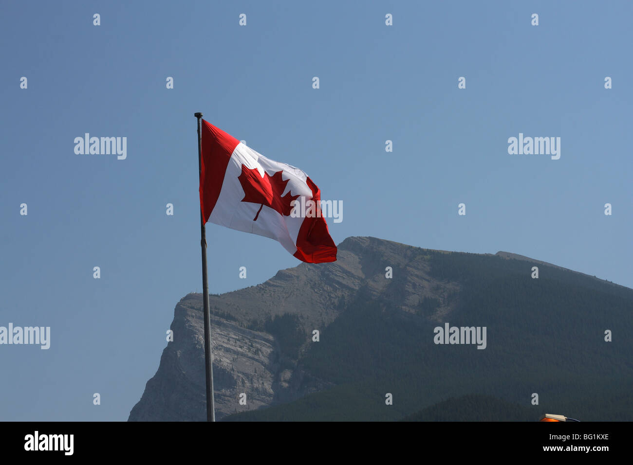 Big Canadian flag high on the bright blue sky Stock Photo - Alamy