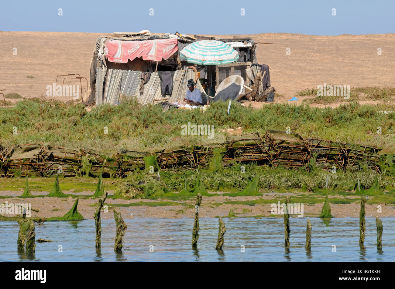 Fisherman sits by hut next to Lagoon, Oualidia, Morocco Stock Photo - Alamy